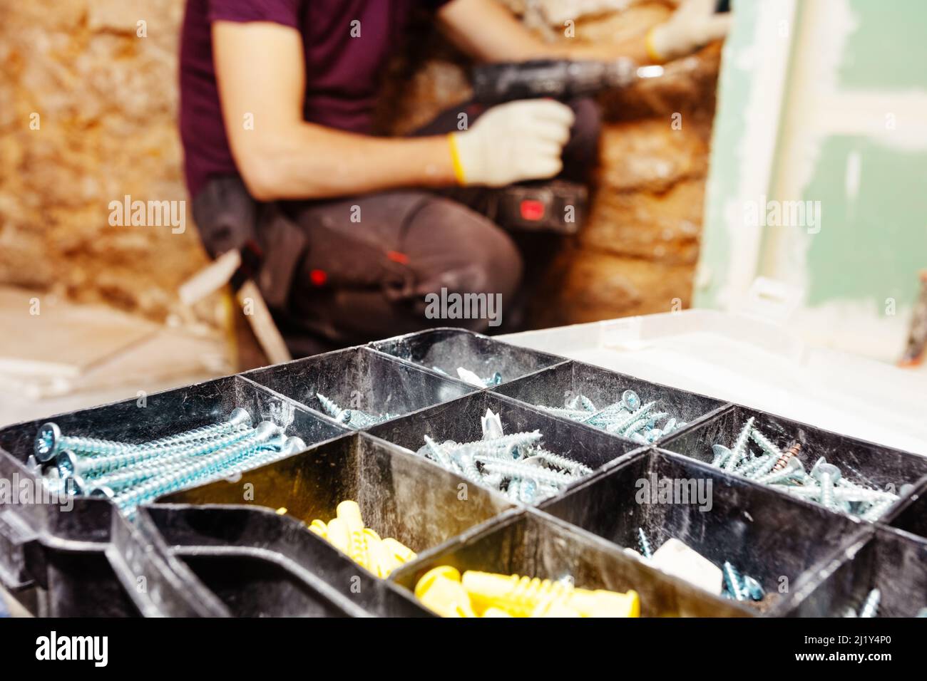 Box with screws, bolts and a man working using screwdriver Stock Photo ...