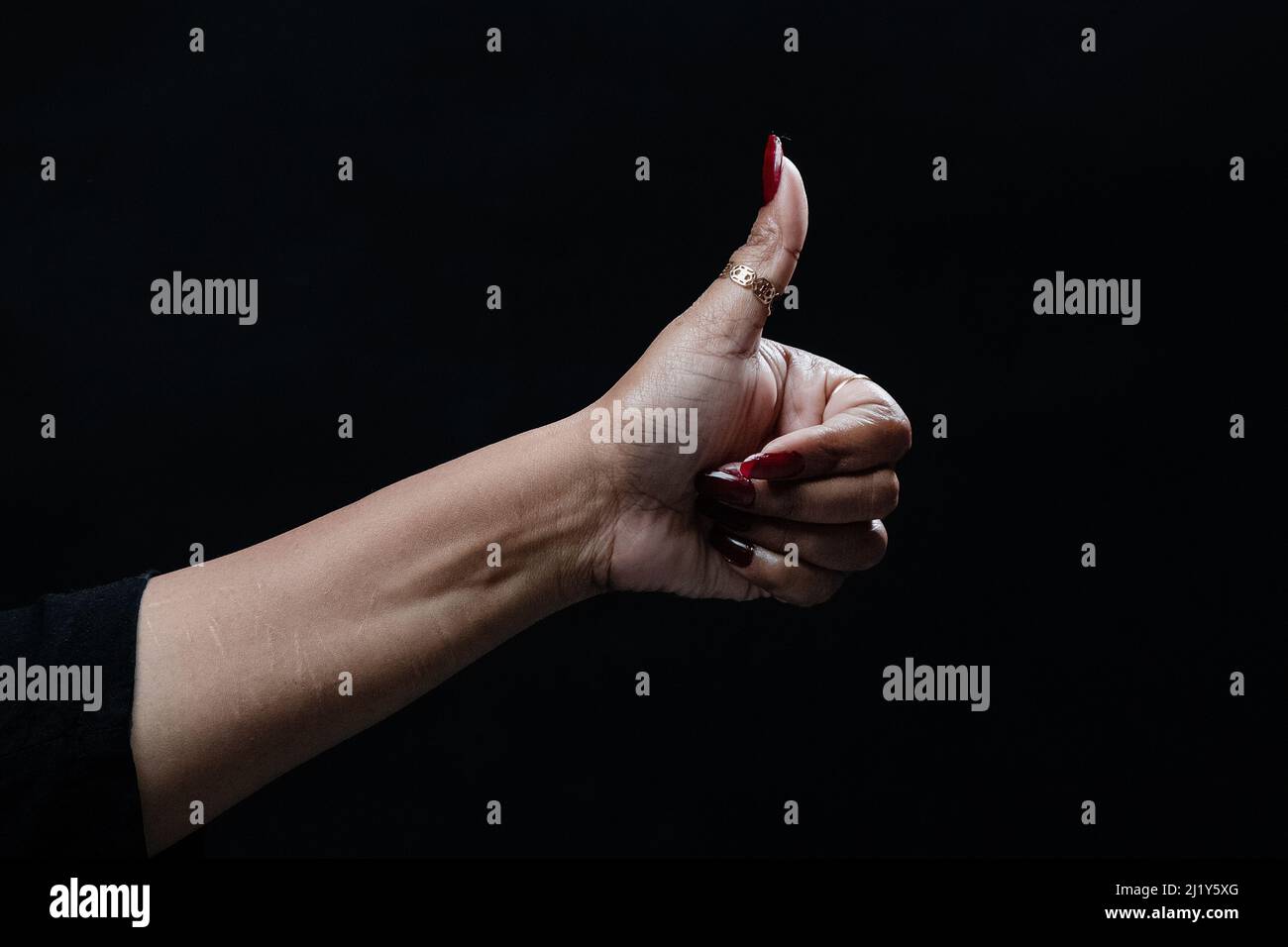 A thumbs up hand gesture isolated on black background Stock Photo - Alamy