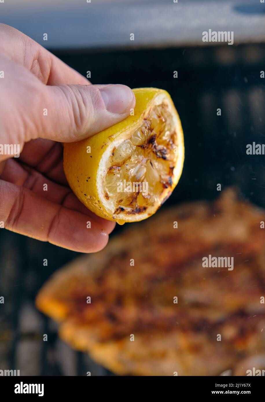 A selective of a hand squeezing a fried lemon Stock Photo - Alamy