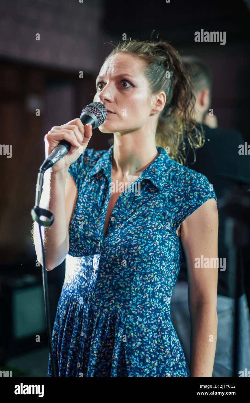 Smiling and witty female stand up actor comedian on stage, talking and ...