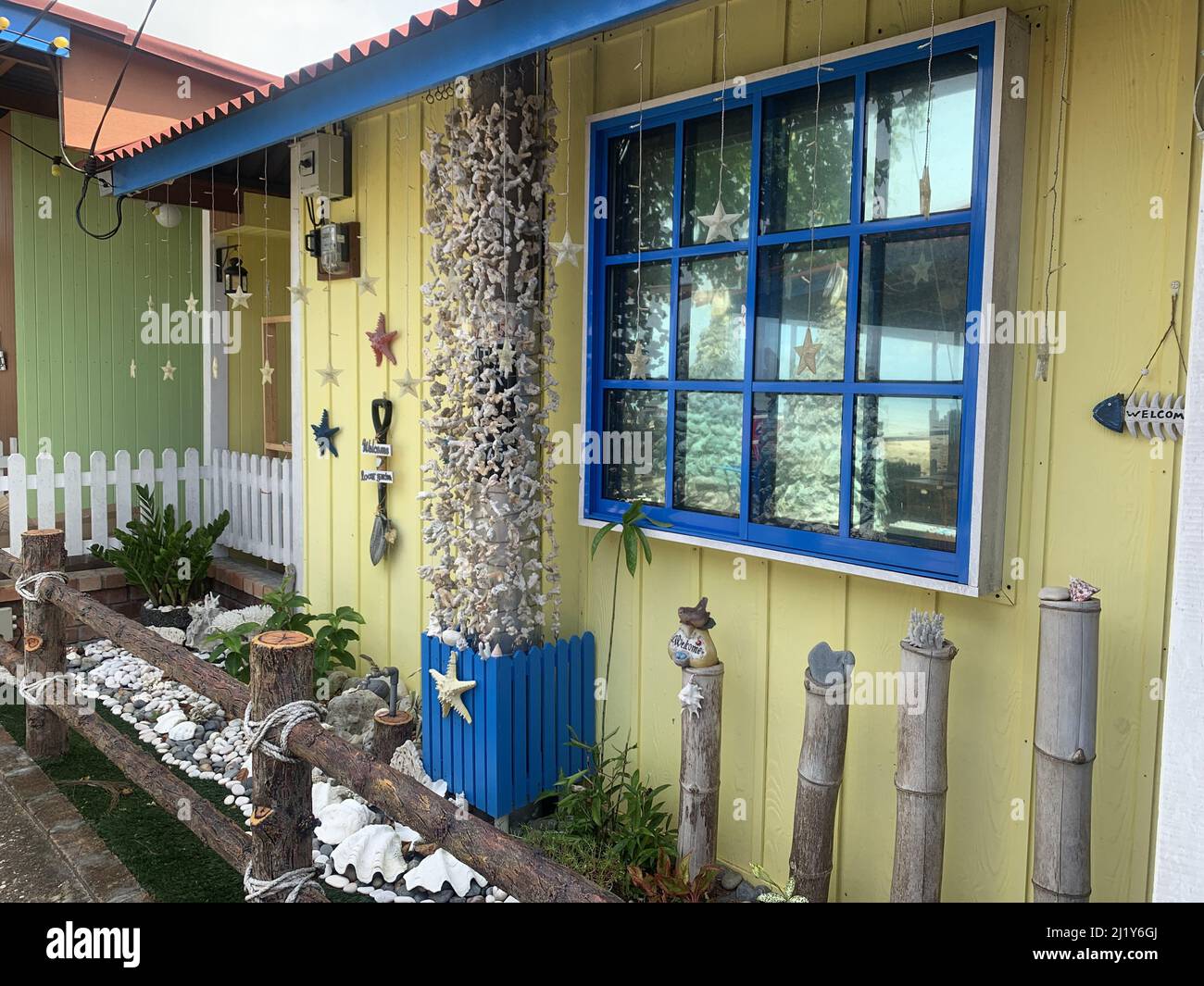 A small house with blue window frames and decorative sea stars hanging ...