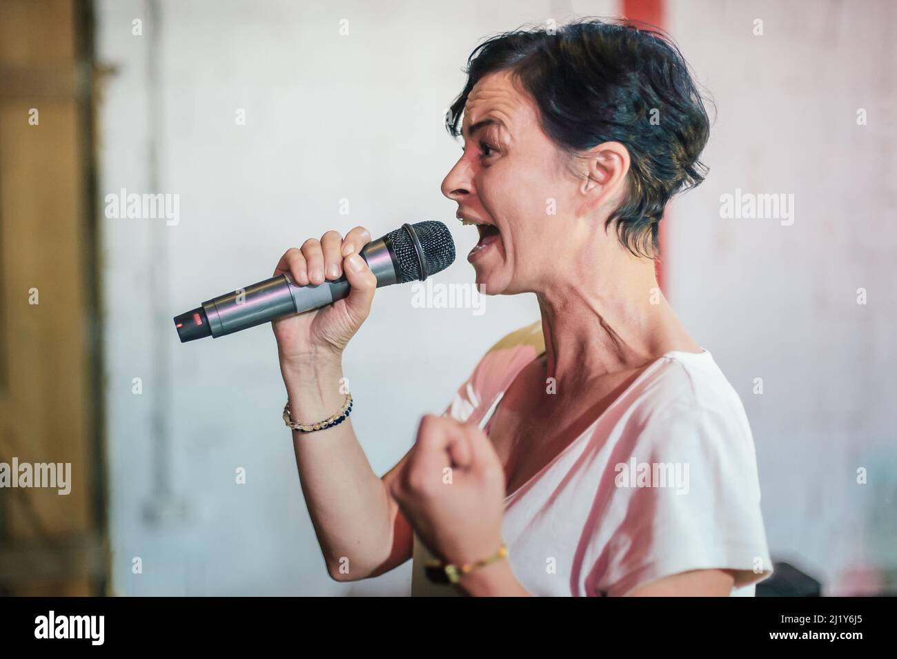Smiling and witty female stand up actor comedian on stage, talking and ...