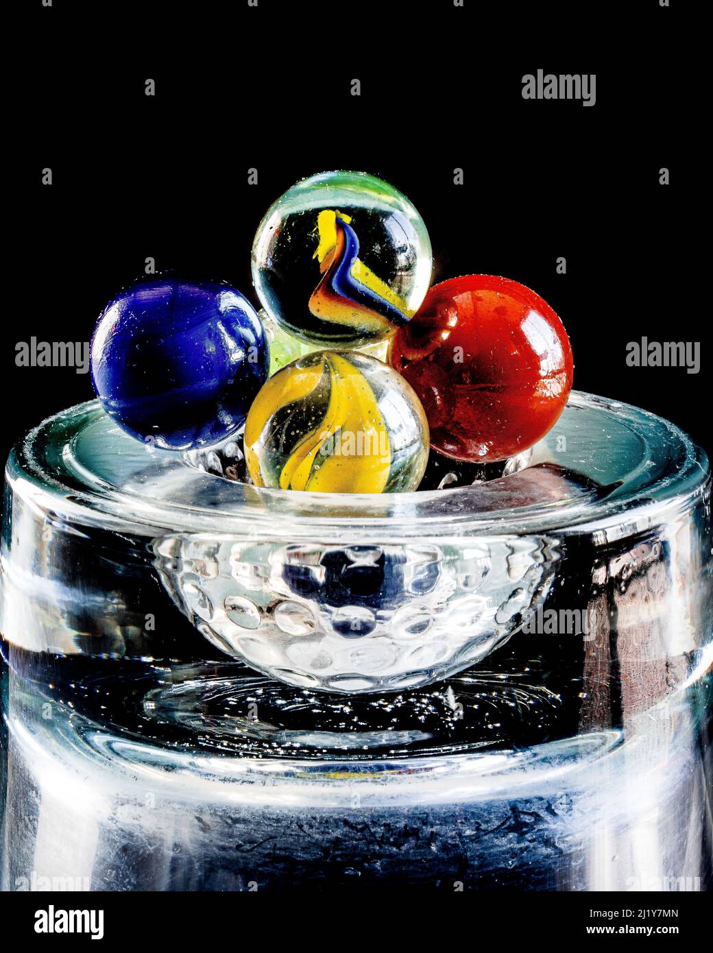 A photo of marble glass balls placed on glass base Stock Photo - Alamy