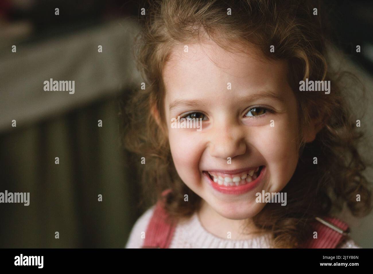 Close-up portrait of a cute little white caucasian girl with a cheeky ...