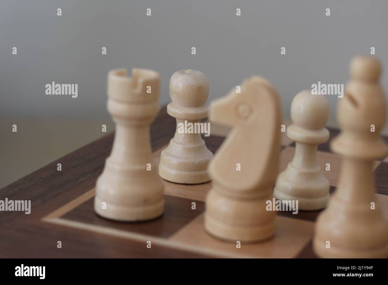 A closeup of beige wooden chess board pawns on a wooden chess board ...