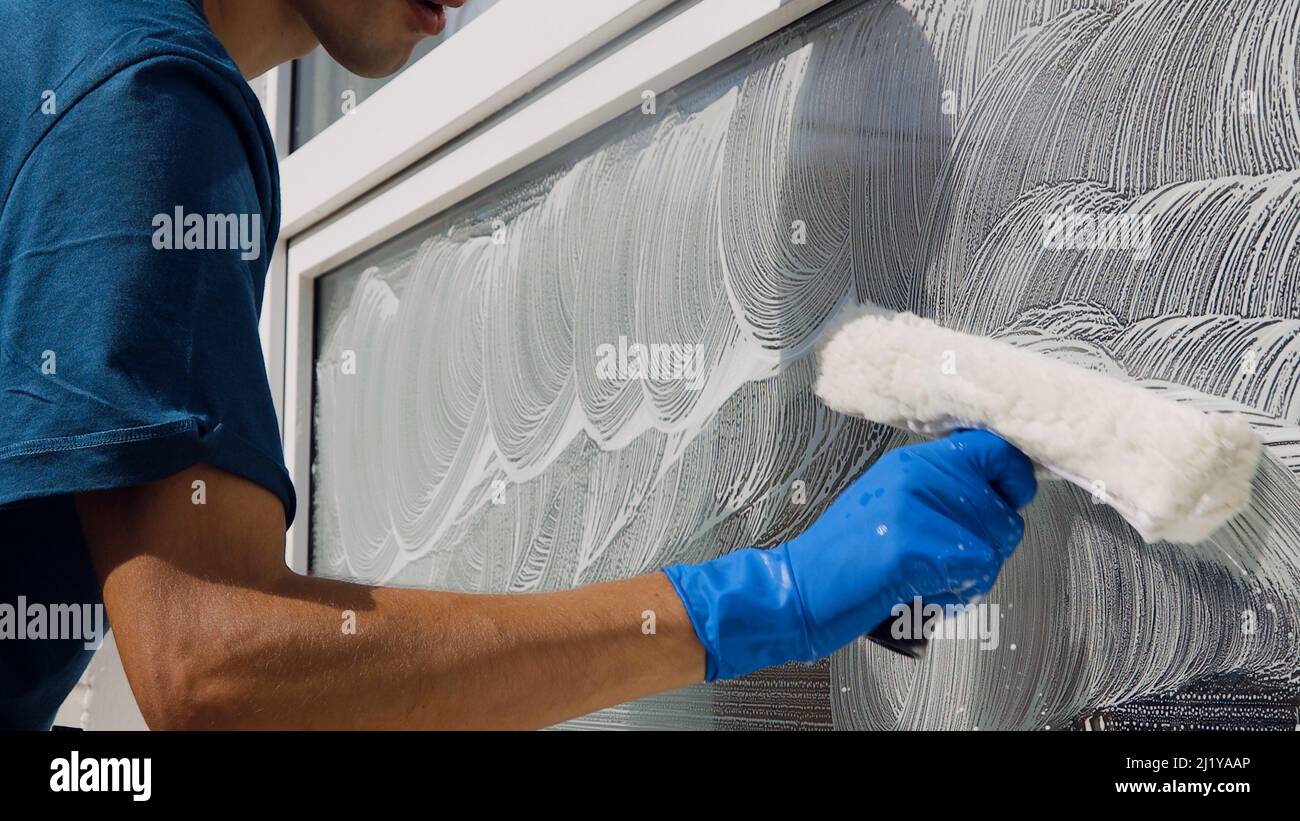 Male professional cleaning service worker in overalls cleans the ...