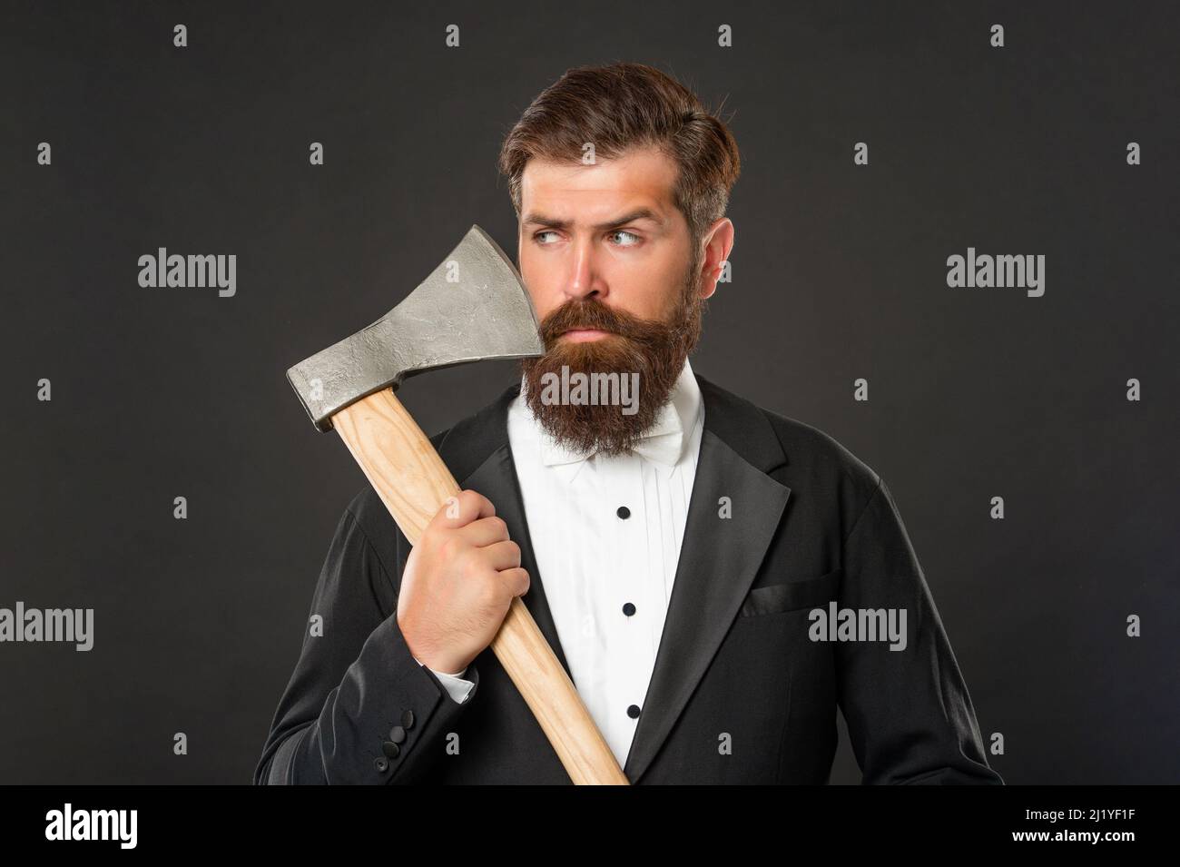 Bearded man hold axe at unshaven face. Axe shaving. Barbering ...