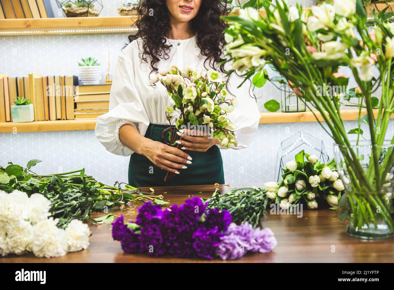 Attractive young woman florist is working in a flower shop Stock Photo ...
