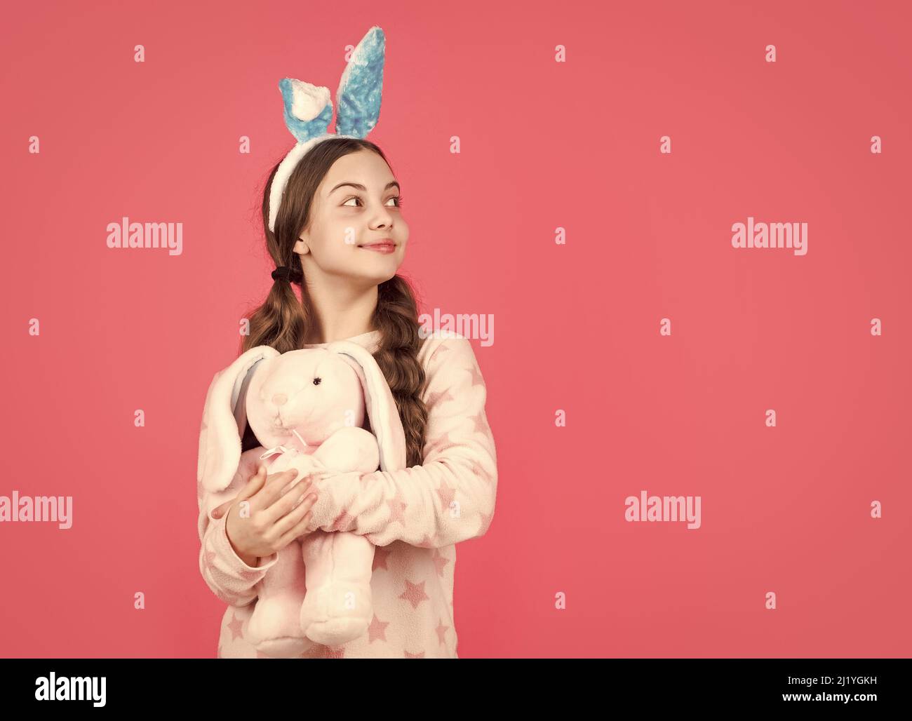 happy easter child girl in bunny rabbit ears and pajamas play with toy ...