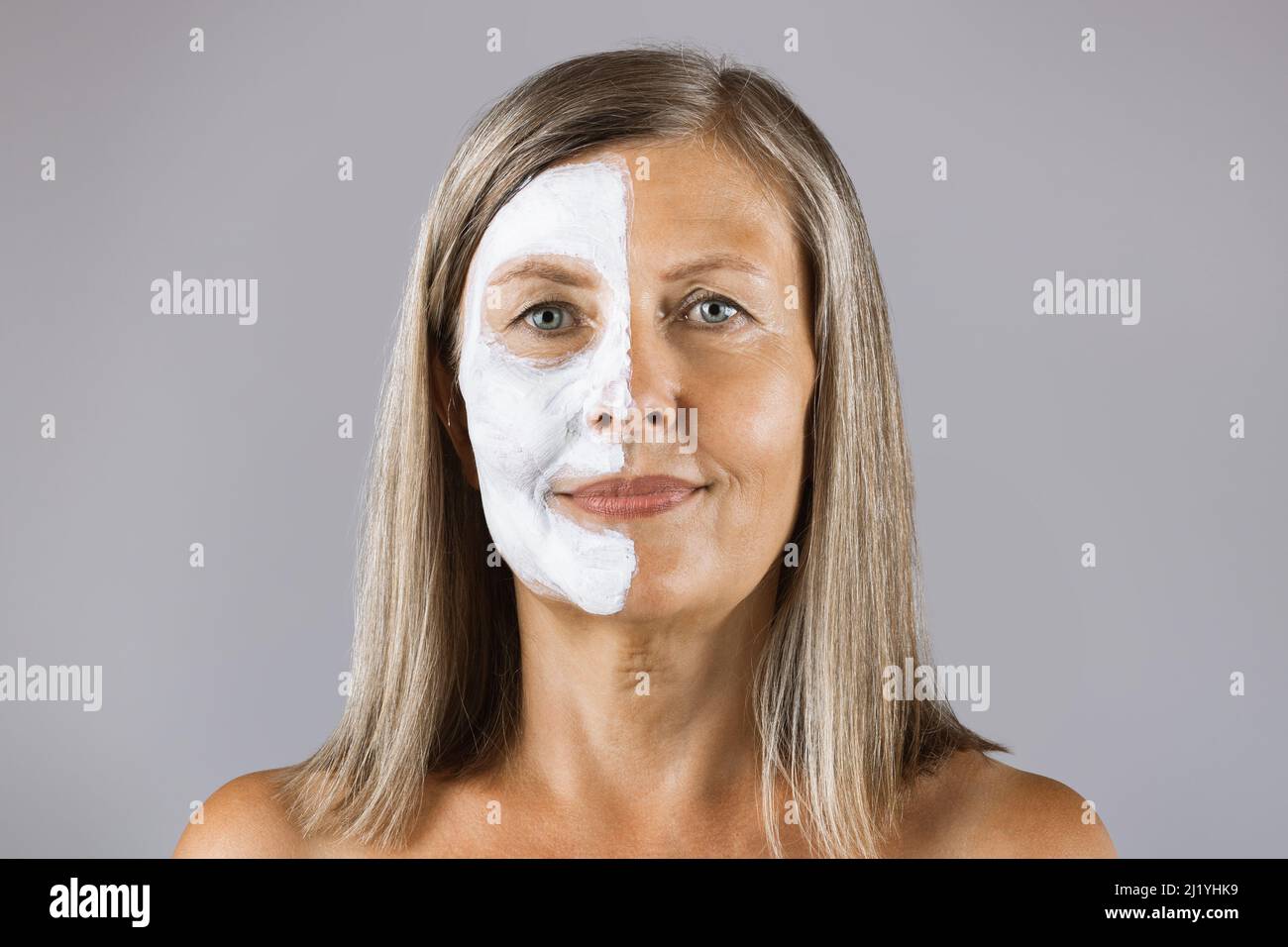Portrait of mature caucasian woman with white cosmetic mask on half of ...