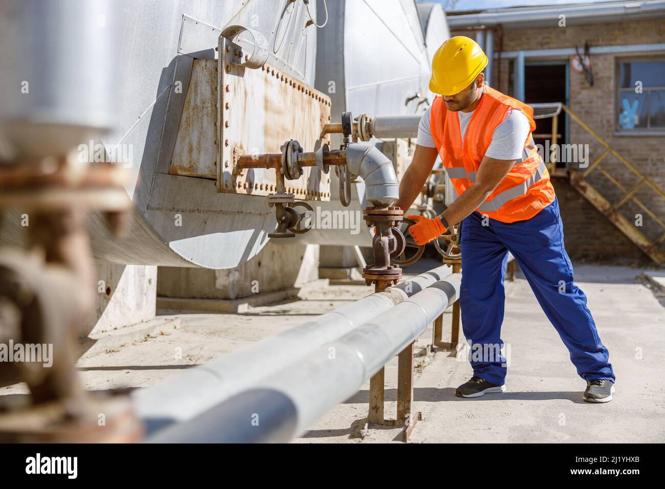 Young worker dressed in safety equipment inside factory Stock Photo - Alamy
