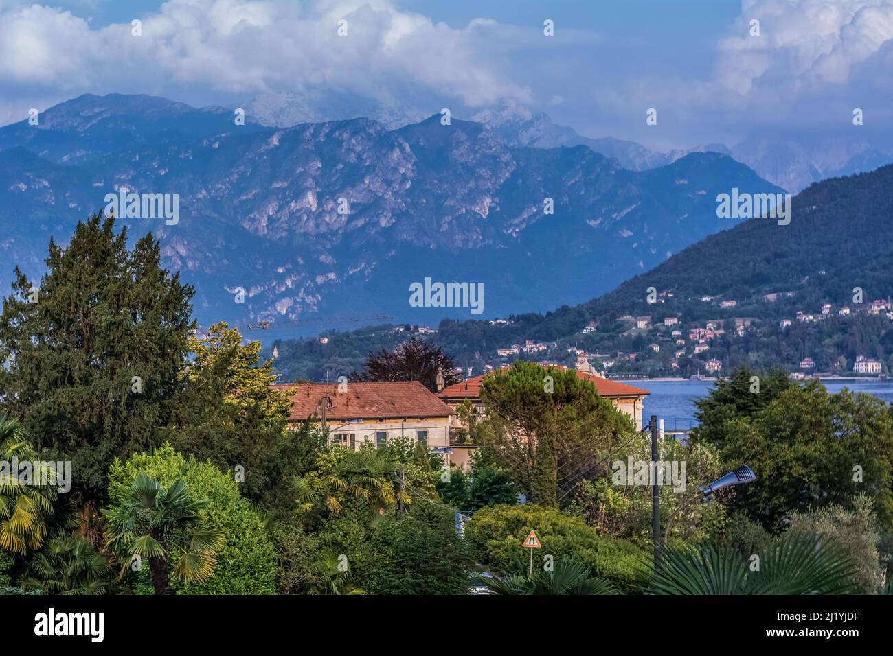 A beautiful scene of trees, houses in Lake Como, Italy with mountains ...