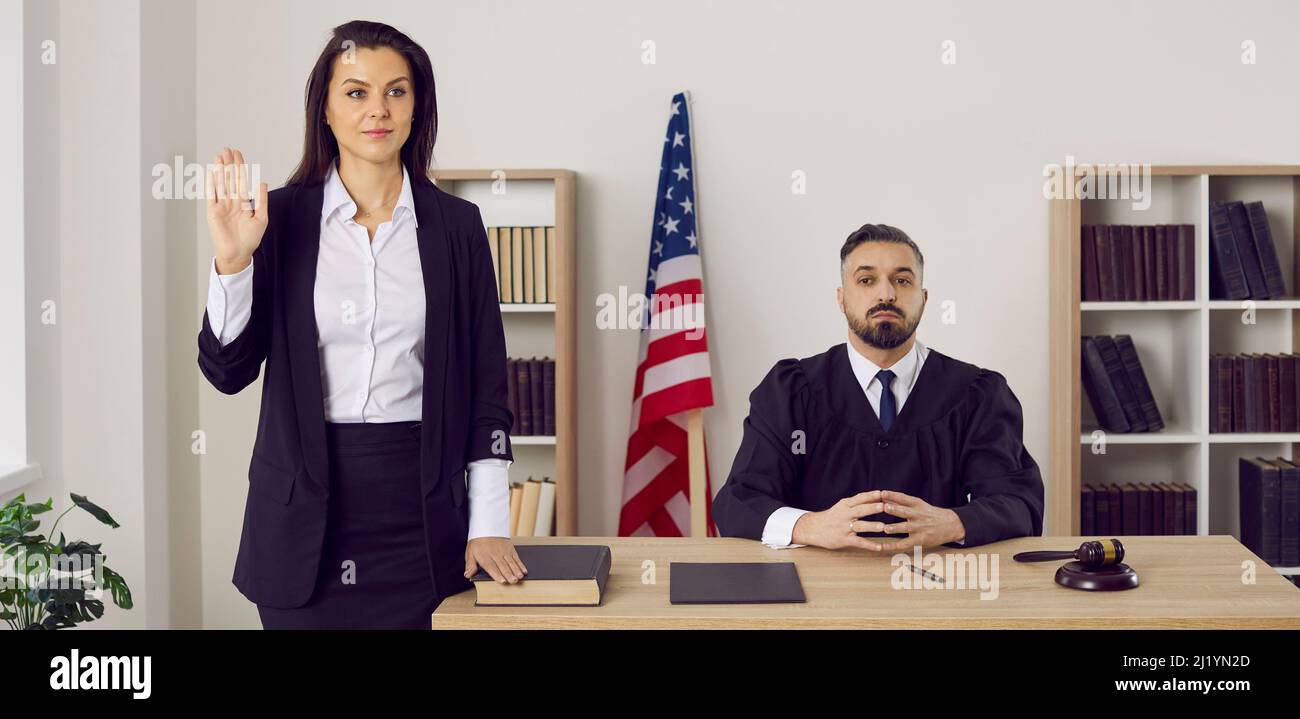 Witness swears on the Bible before giving a testimony during a trial in ...