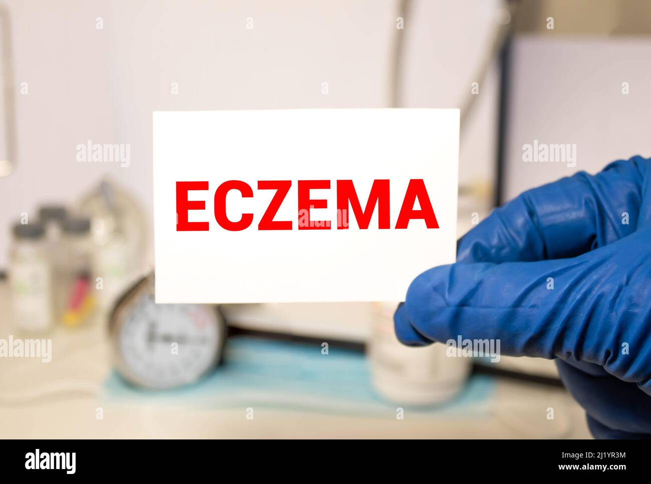 Doctor's hands in blue gloves shows the word eczema. Medical concept ...