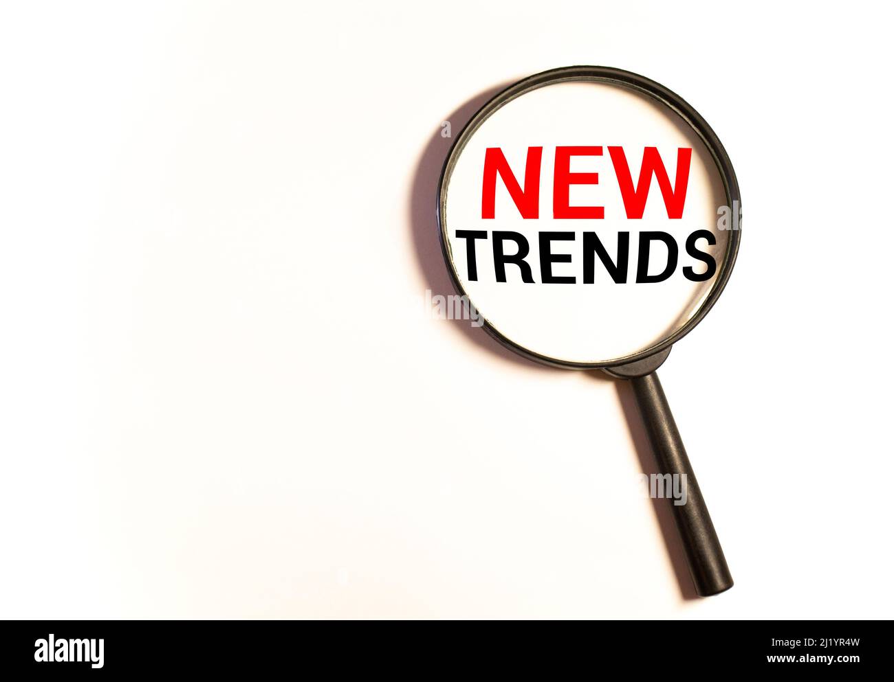 NEW TRENDS text written on magnifying glass. Main trend of changing ...