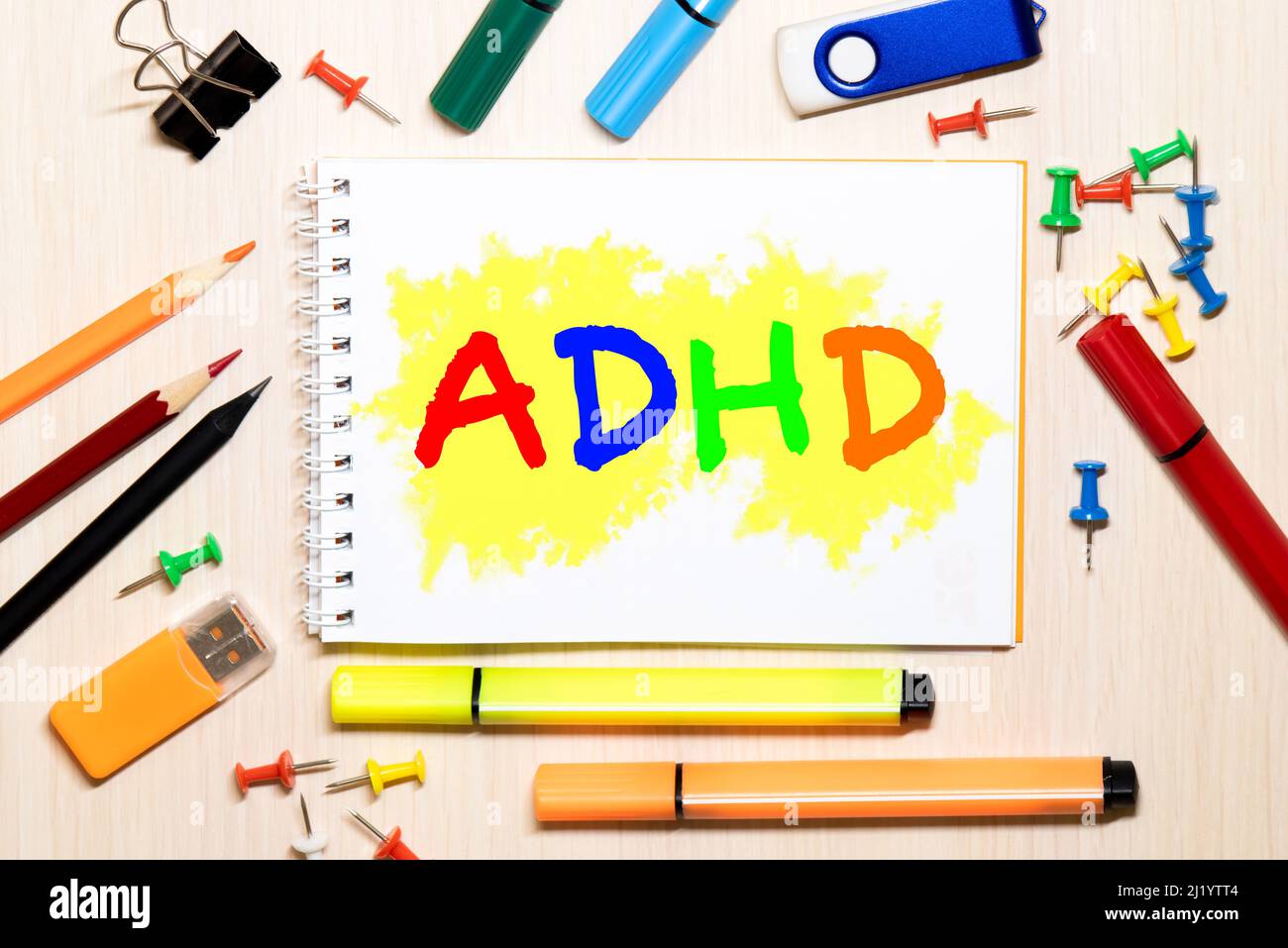 ADHD written on sheet of paper by crayons. ADHD is Attention deficit ...