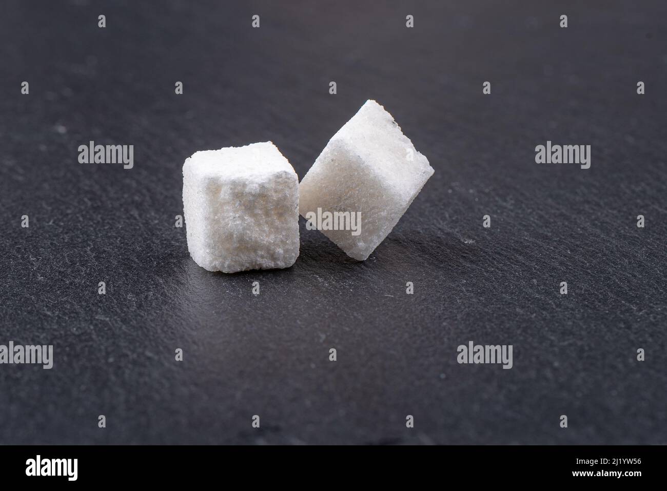 Cubes of white beet sugar refined on a stone background. Copy space ...