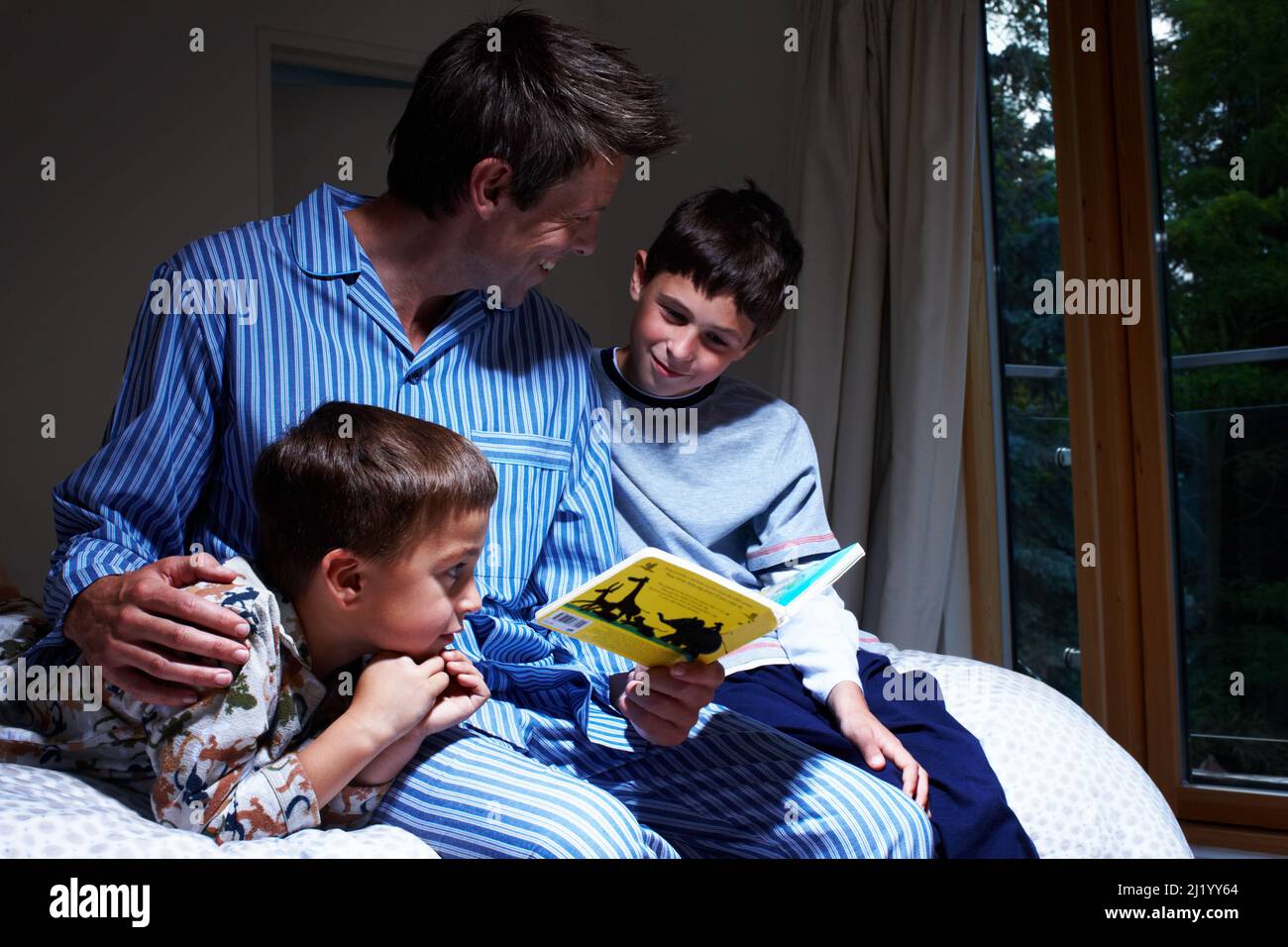 A tale before bedtime - Family Bonding. A father reading to his two ...