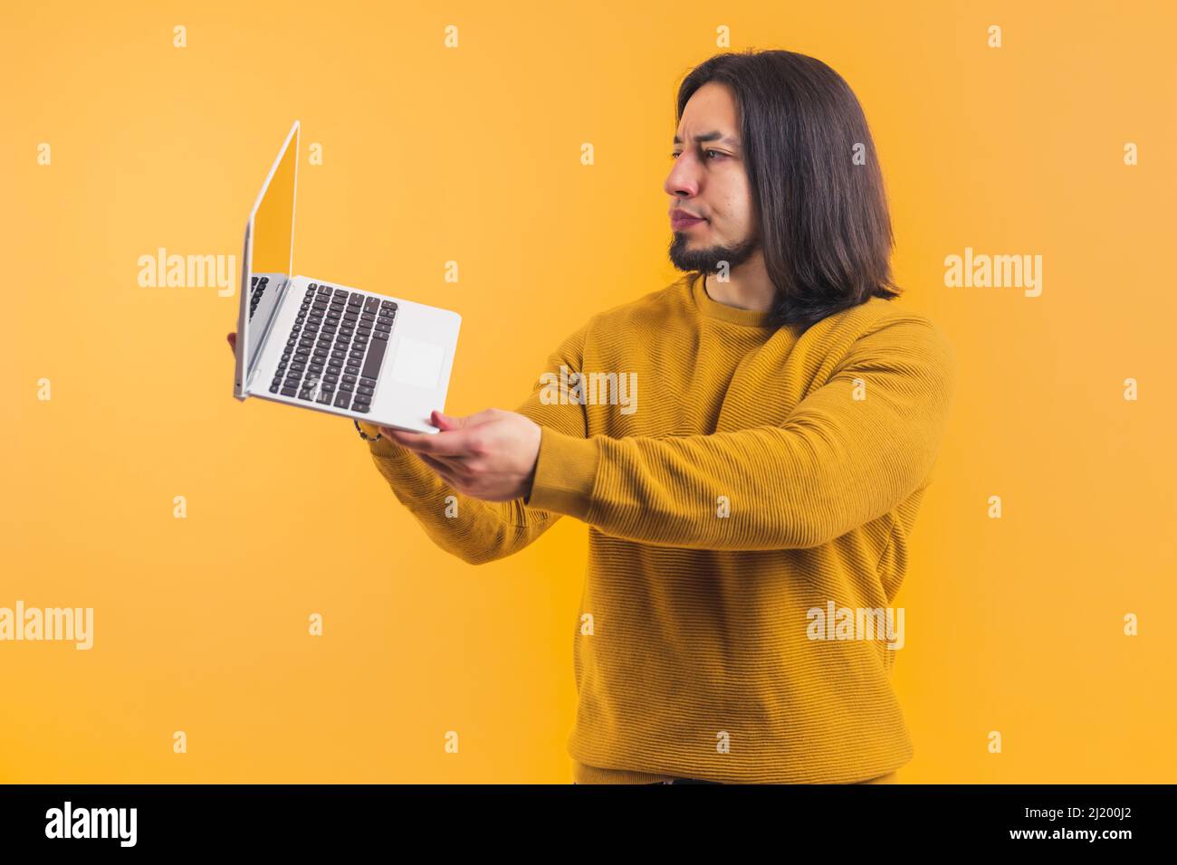 Disgusted angry caucasian guy with facial hair holding laptop up and ...