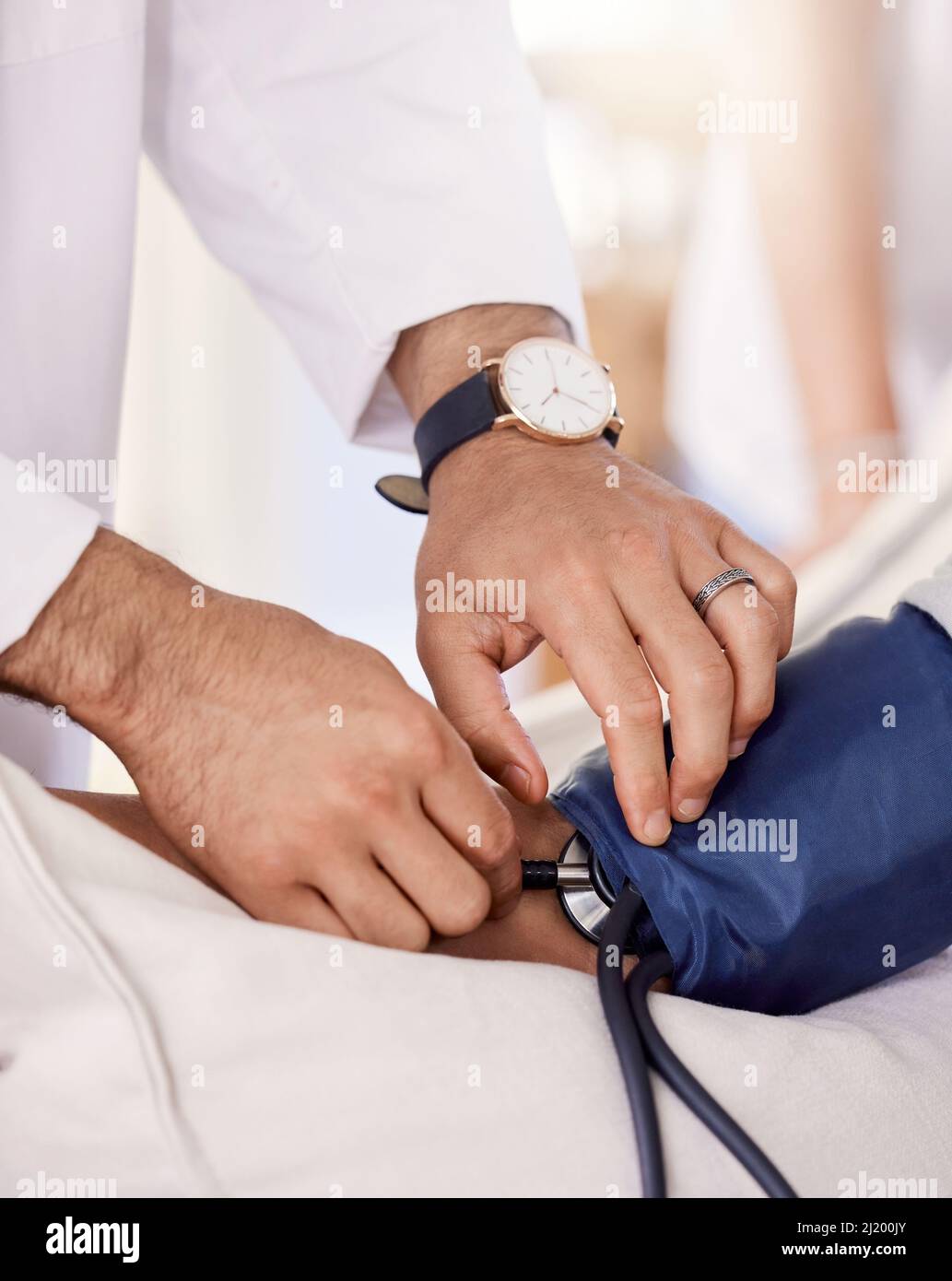 Let me check you blood pressure. Shot of a male doctor examining a ...