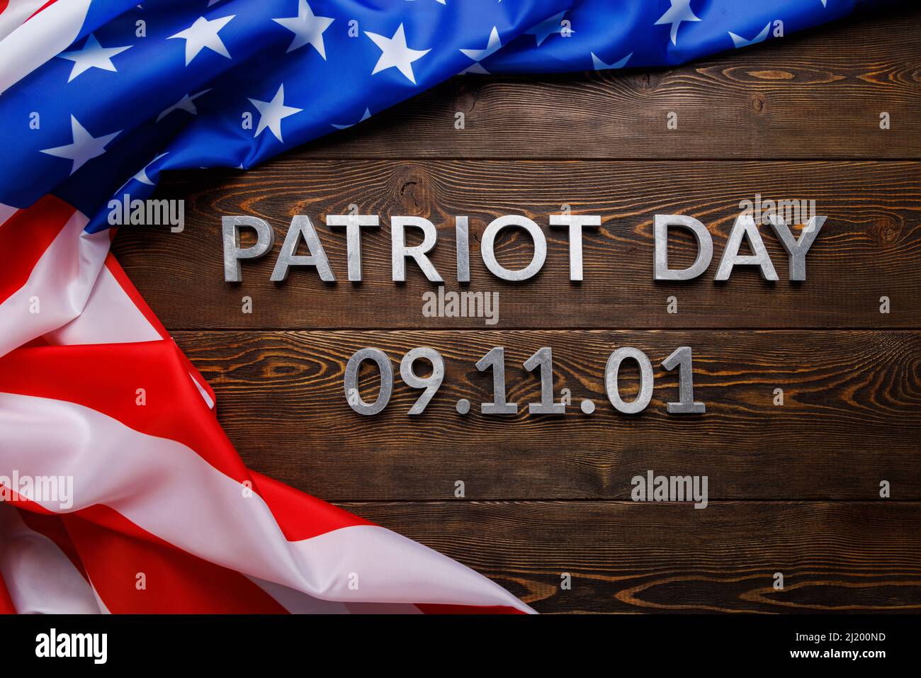 the words patriot day laid with silver metal letters on wooden board ...