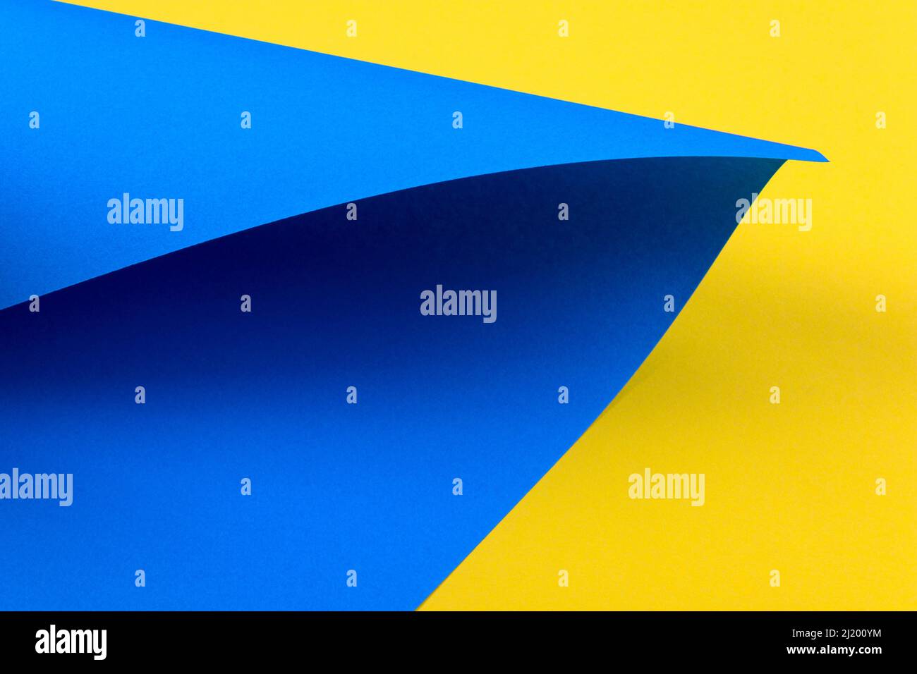Blue and yellow paper is curved by a wavy line. Background of shape and ...