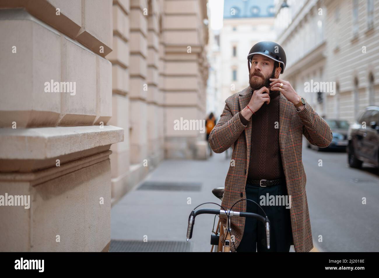 Good looking man puts on helmet before bicycle ride. Safety and eco ...