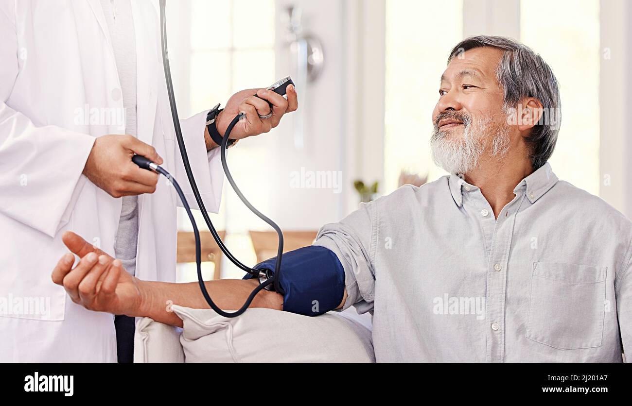 How am I doing, Doctor. Shot of a male doctor examining a senior ...