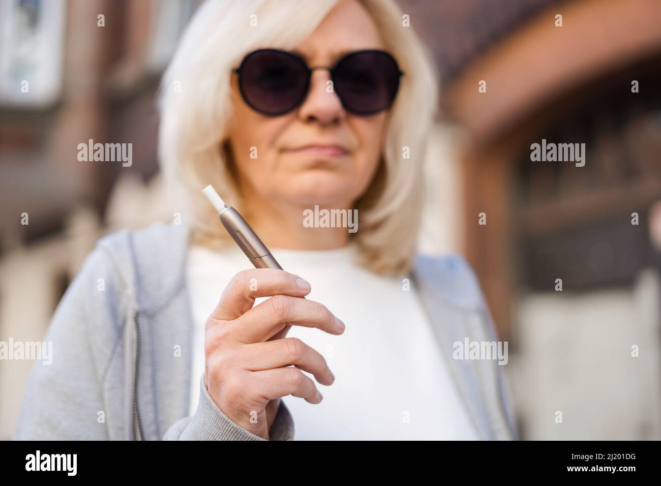 Middle Aged Blonde European Woman Smoking Heated Tabacco E Cigarette