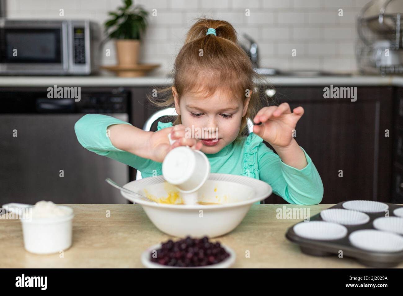 Little girl making dough in kitchen at home. Small child cooking. Kid ...