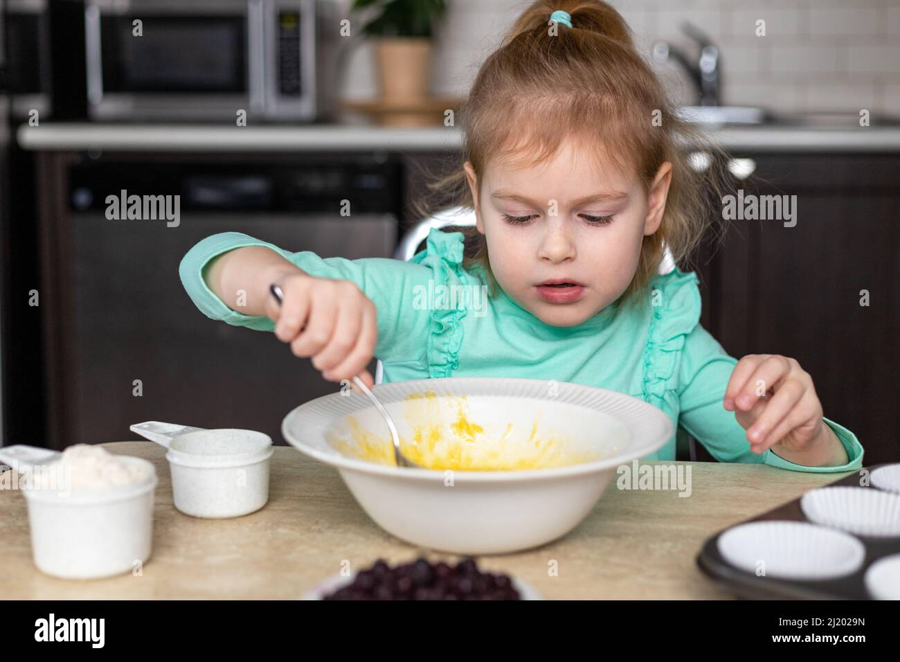 Little kid making dough for baking homemade muffins. Child cooking in ...