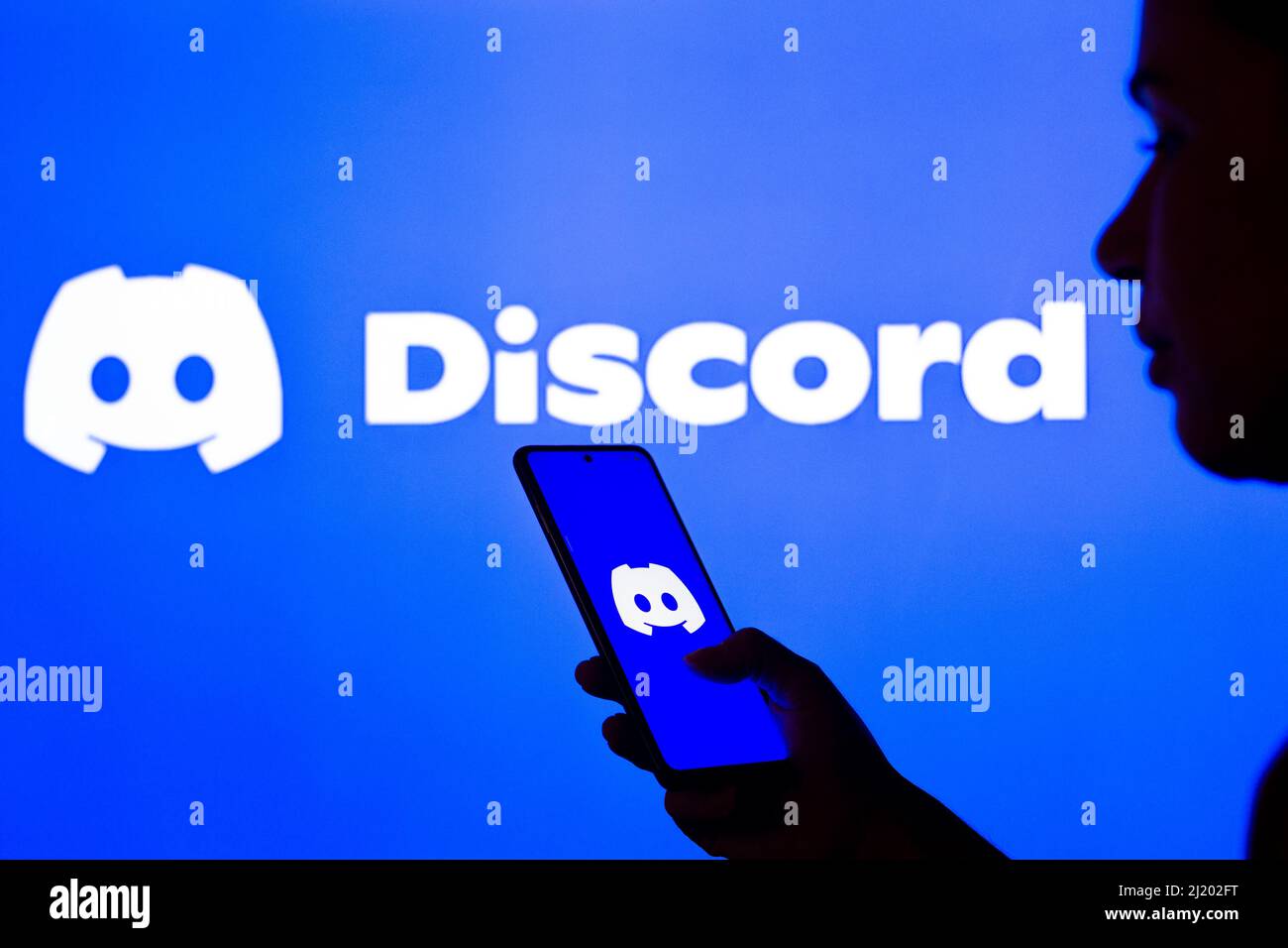 In this photo illustration, a woman's silhouette holds a smartphone ...