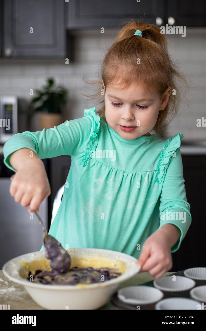 Little girl mixing ingredients for homemade blueberry muffins. Small ...