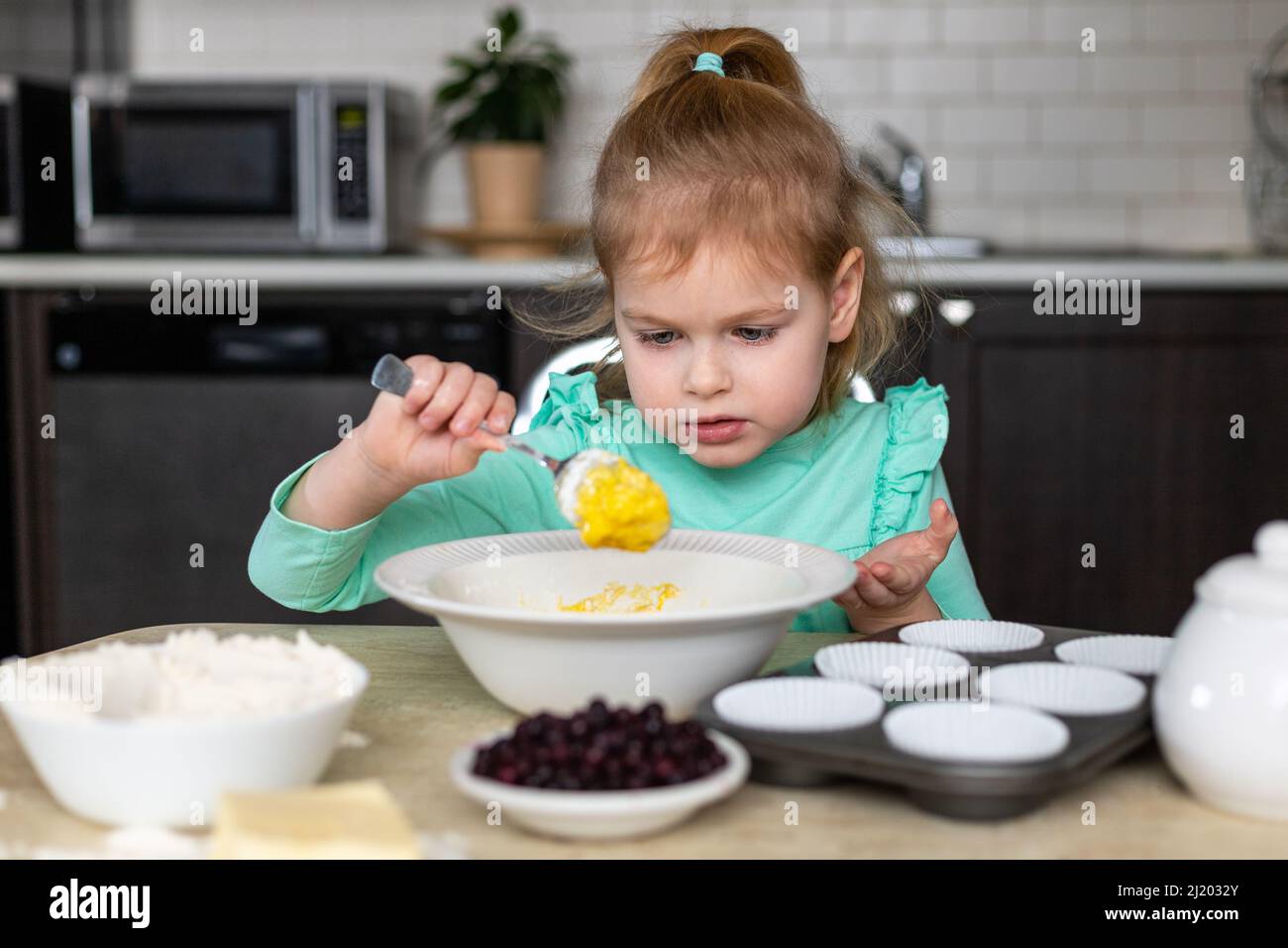 Little girl making dough in kitchen at home. Small child cooking food ...