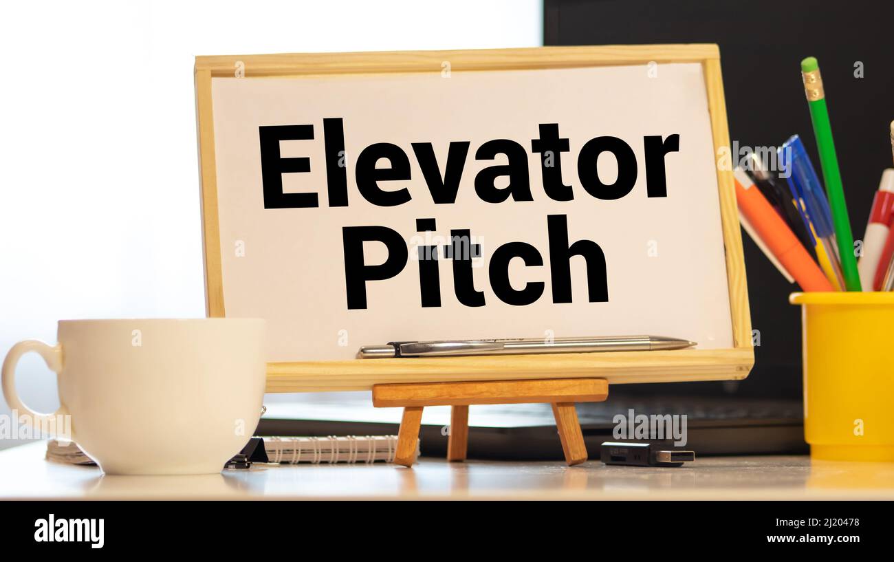 elevator pitch text message on white paper and office supplies, pen ...