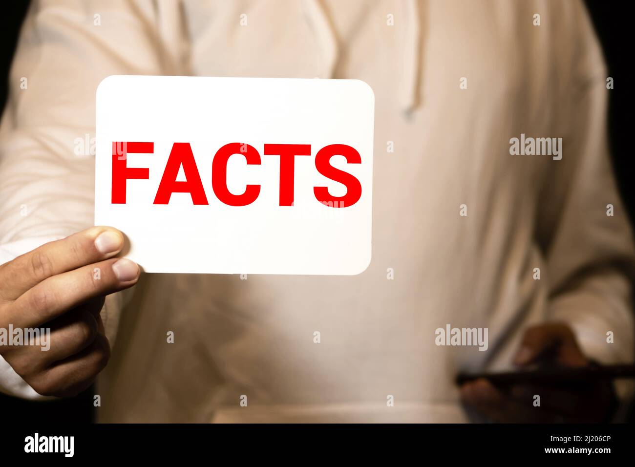 ManBusiness card with the word facts in the hand of a businessman.y ...