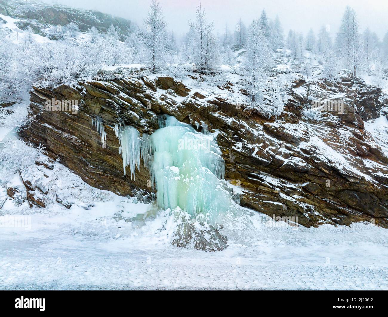 Large ice stalactites hang from the high cliff Stock Photo - Alamy