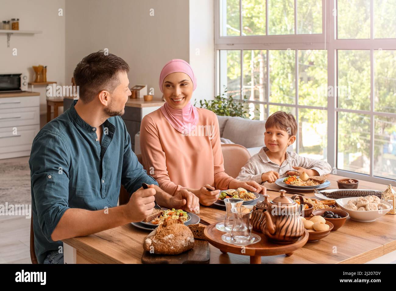 Muslim family having breakfast together. Celebration of Eid al-Fitr ...