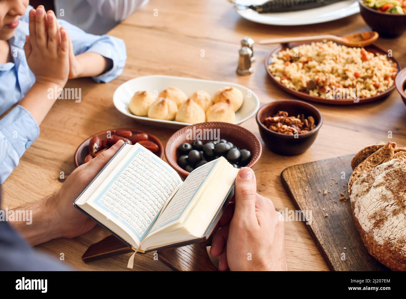 Muslim family praying together before breakfast. Celebration of Eid al ...