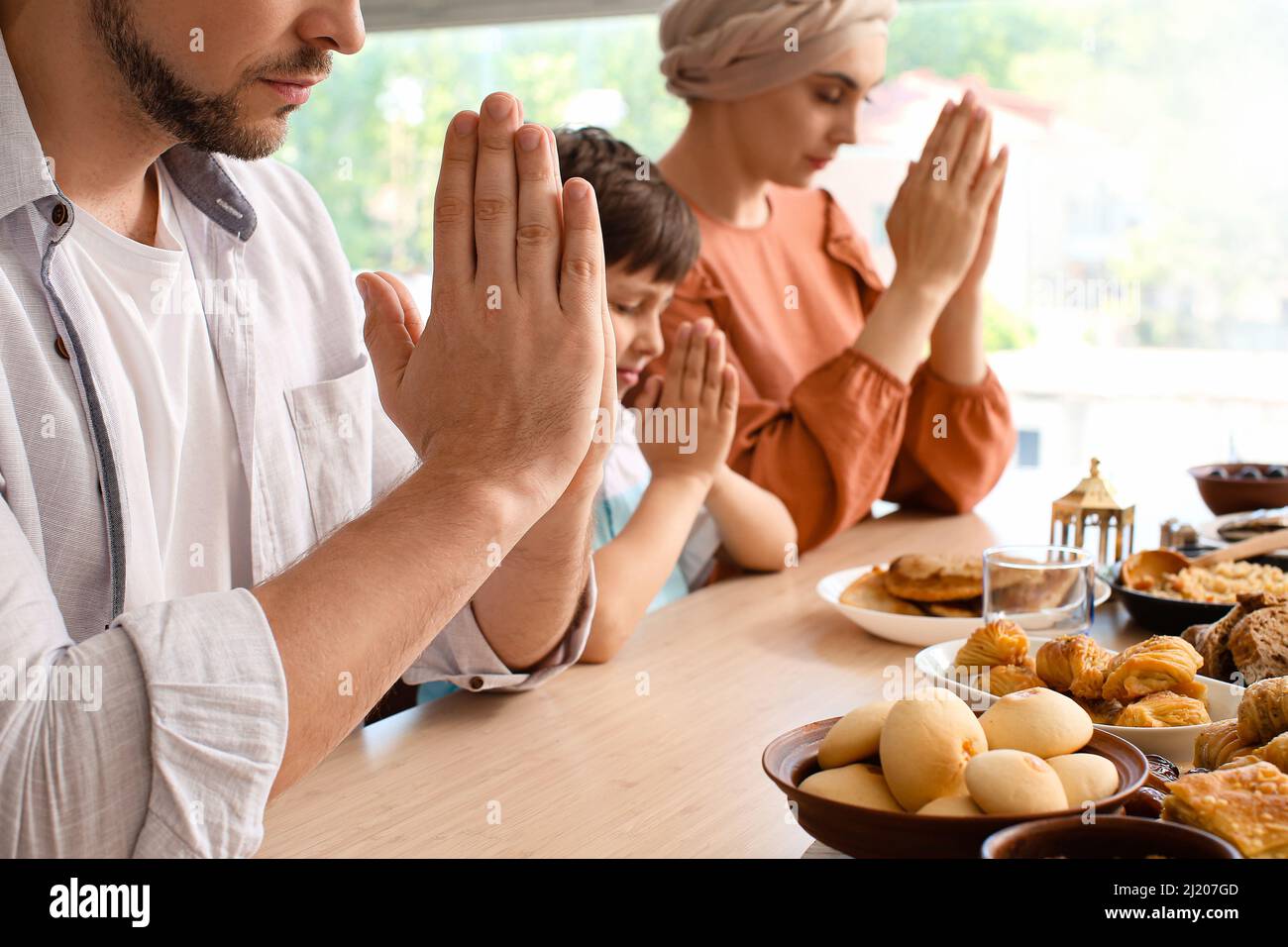 Muslim family praying together before breakfast. Celebration of Eid al ...