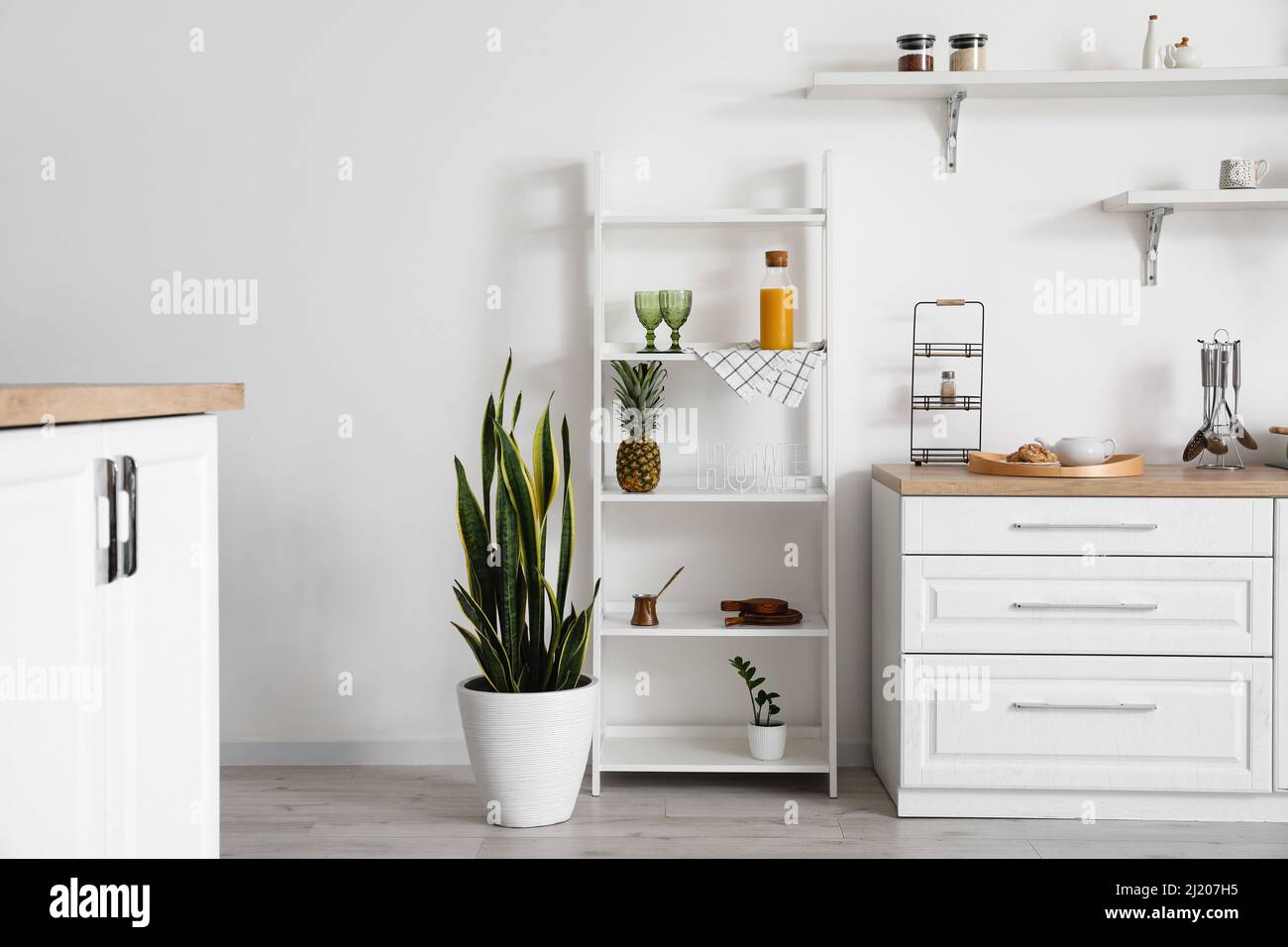 Interior of light modern kitchen with shelf unit Stock Photo - Alamy