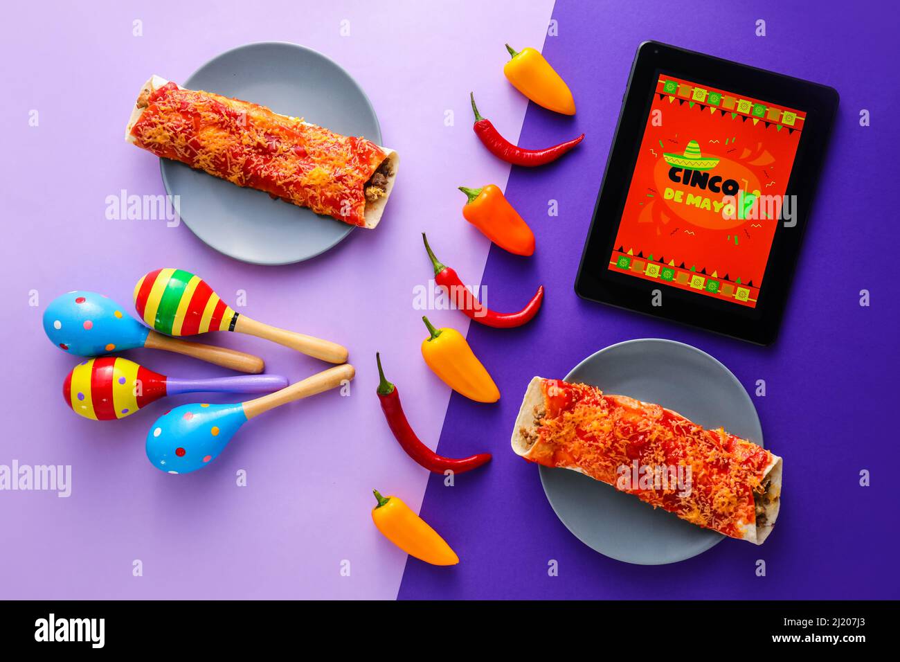 Traditional Mexican enchilada with maracas and tablet computer on color ...
