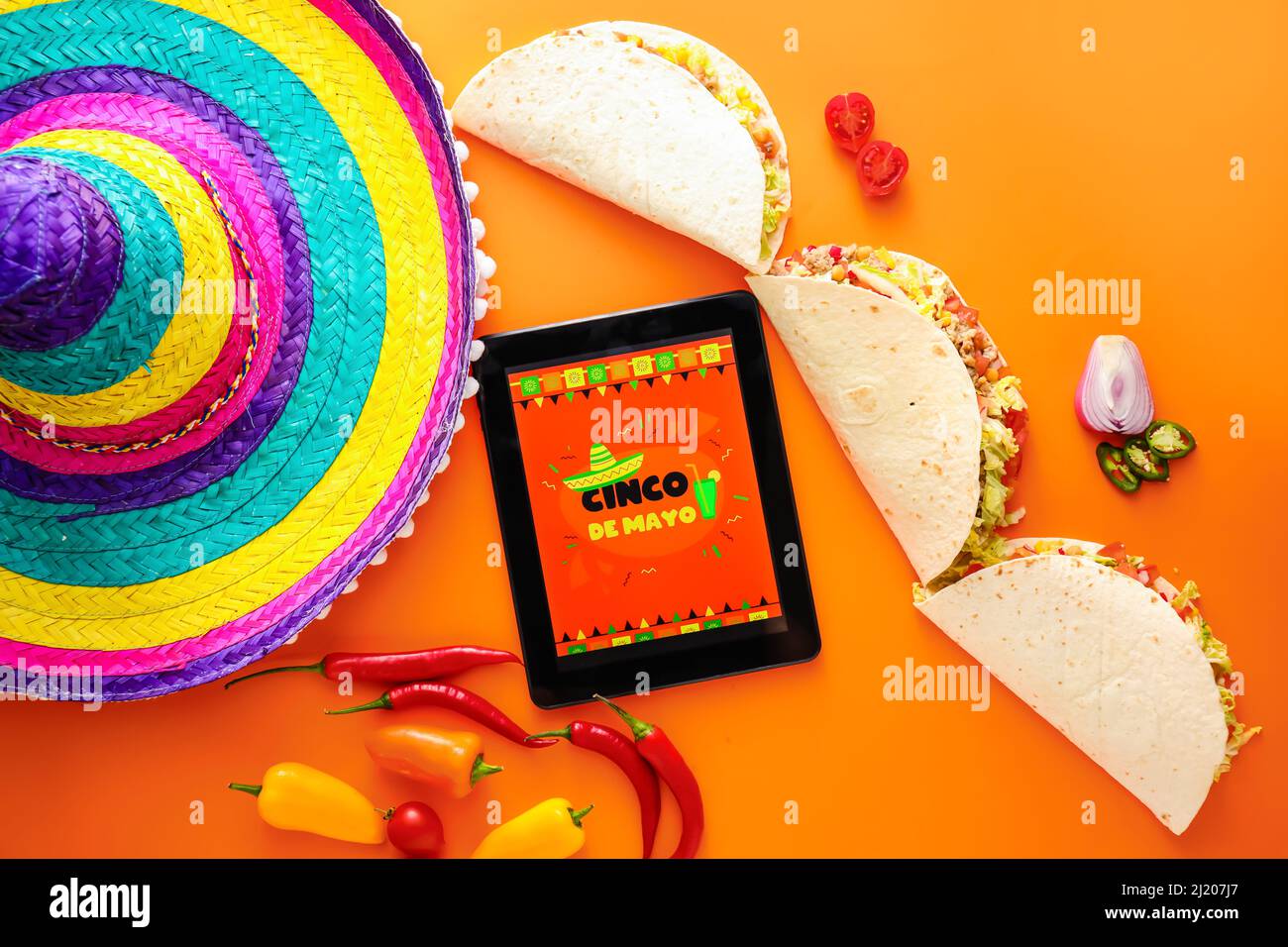 Traditional Mexican tacos with sombrero and tablet computer on color ...