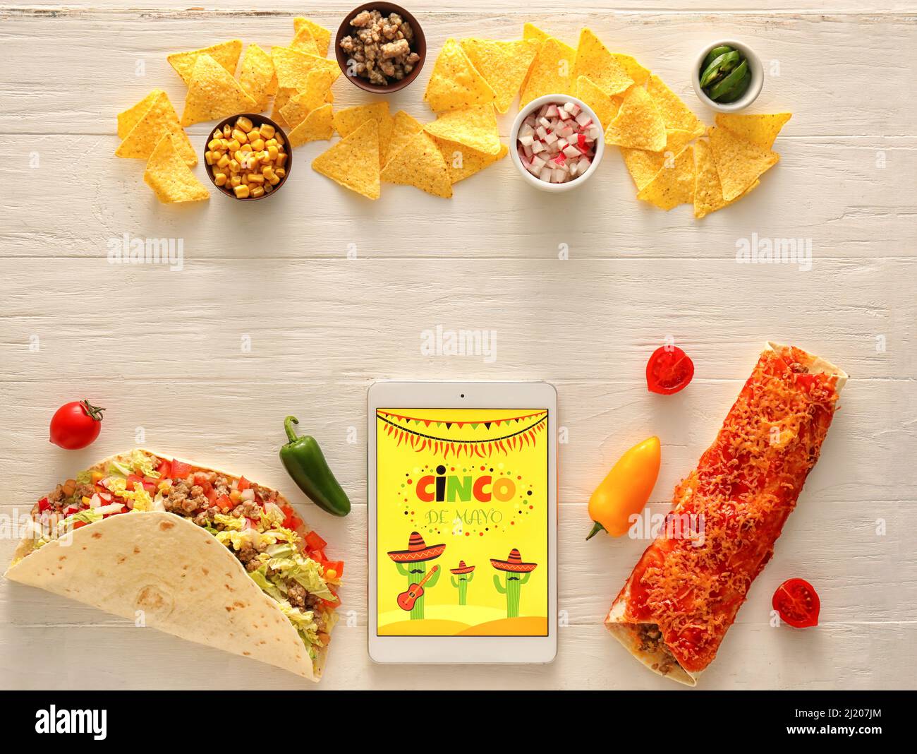 Traditional Mexican food and tablet computer on white wooden background ...