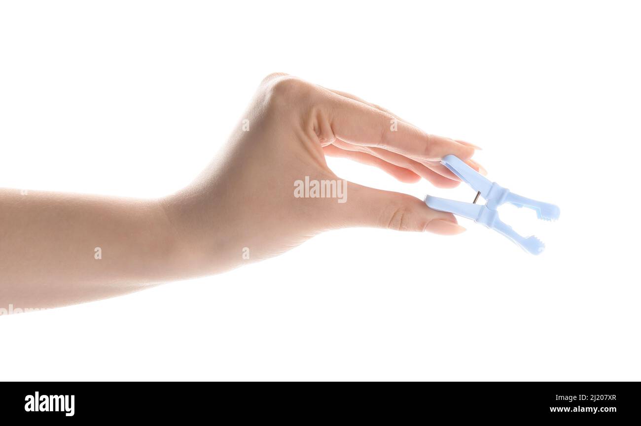 Female hand with plastic clothes pin on white background Stock Photo ...