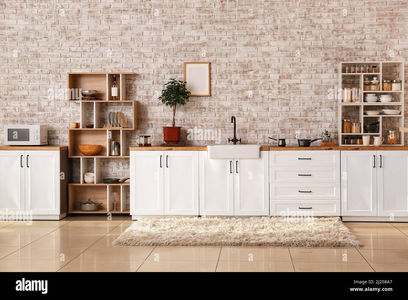 Interior of modern kitchen with white counters, shelving units and ...