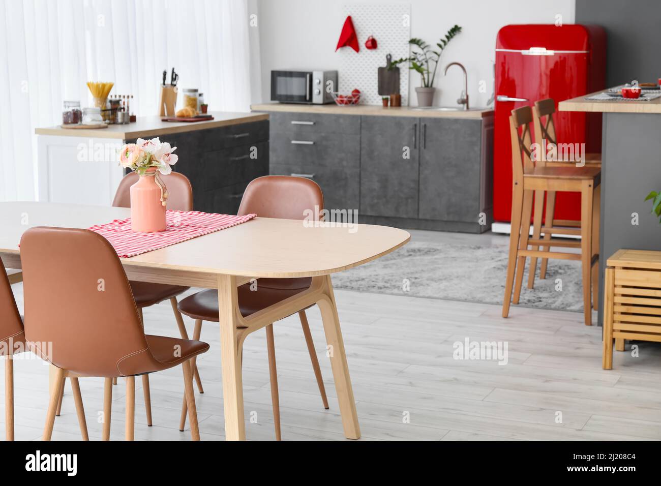 Interior of modern kitchen with red fridge, counters and dining table ...