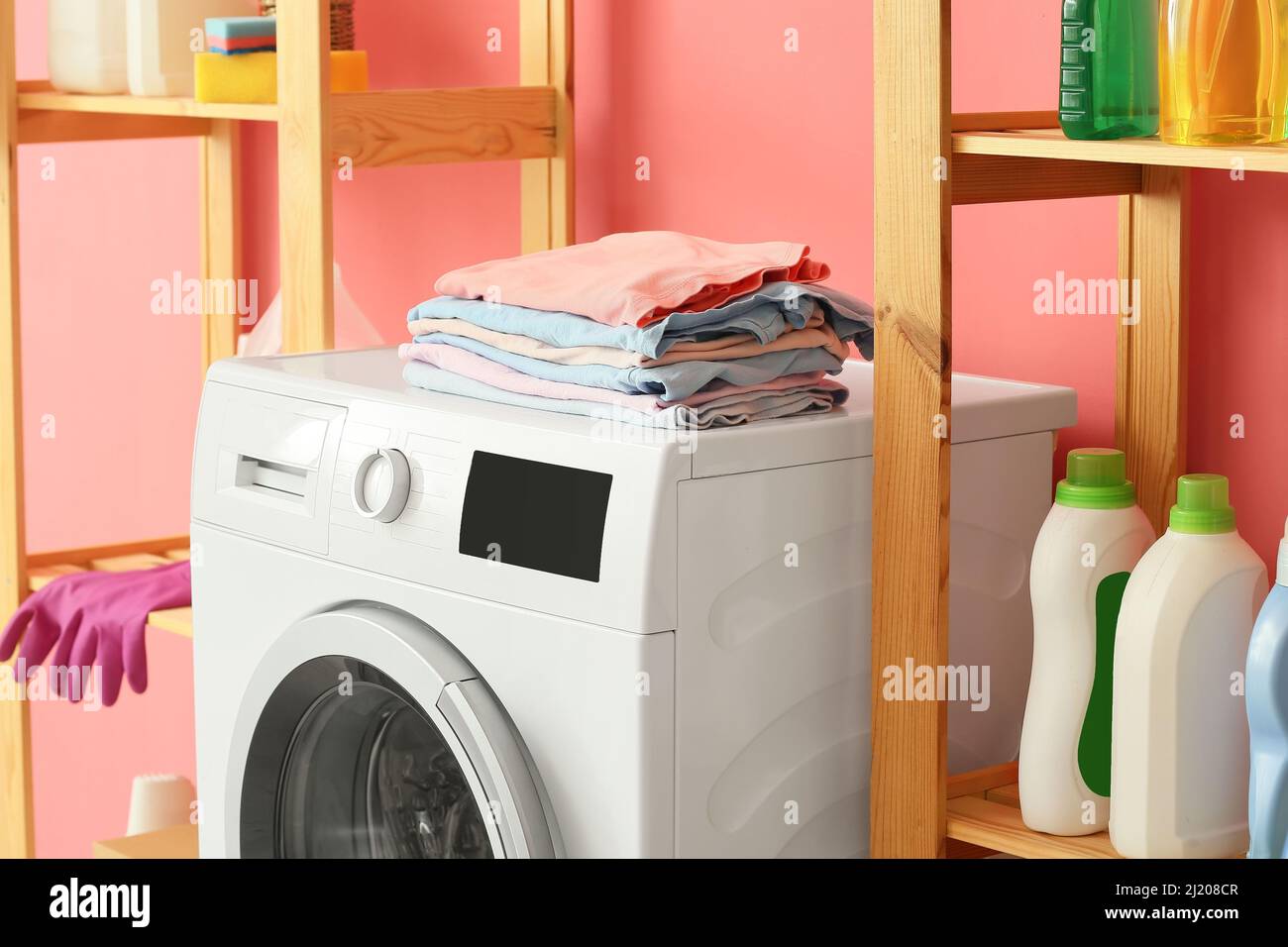 Stack of clean clothes on washing machine in laundry room Stock Photo ...