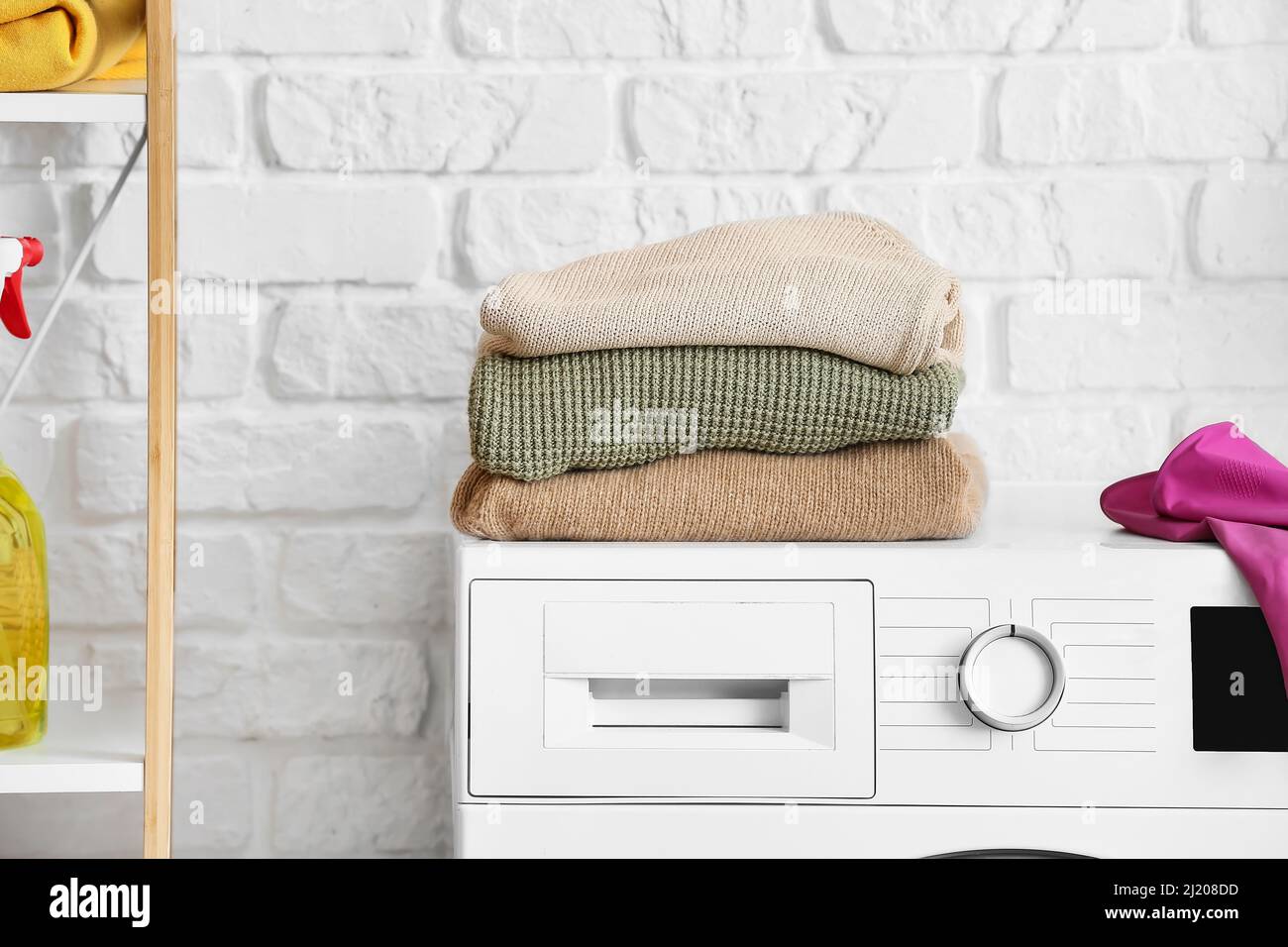 Stack of clean clothes on washing machine in laundry room Stock Photo ...