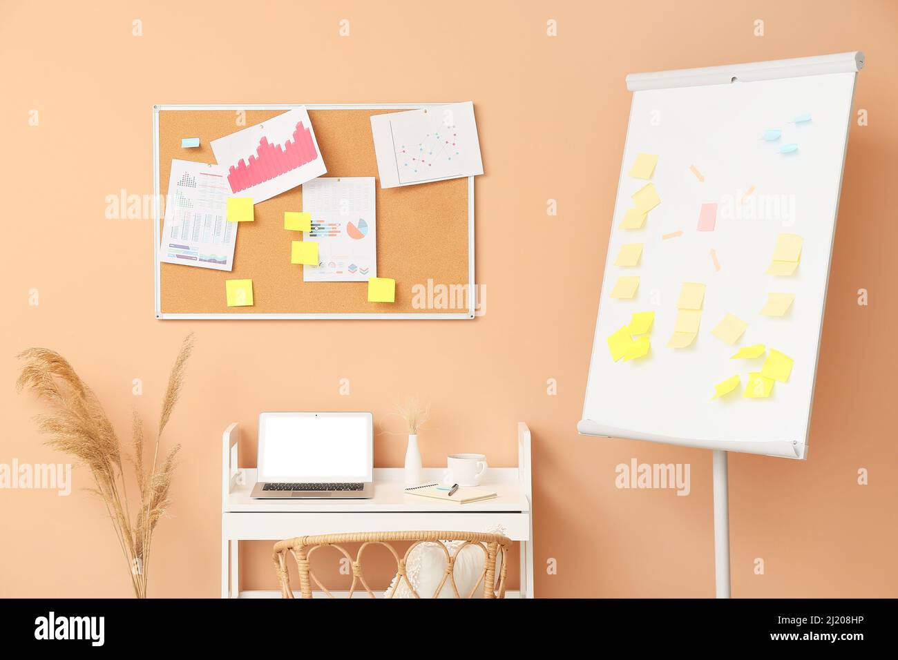 Modern workplace with sticky notes and flipchart near beige wall Stock ...